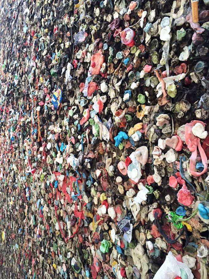A riot of reds, pinks, blues, and greens packed together so tightly that the original wall has completely surrendered beneath it all.