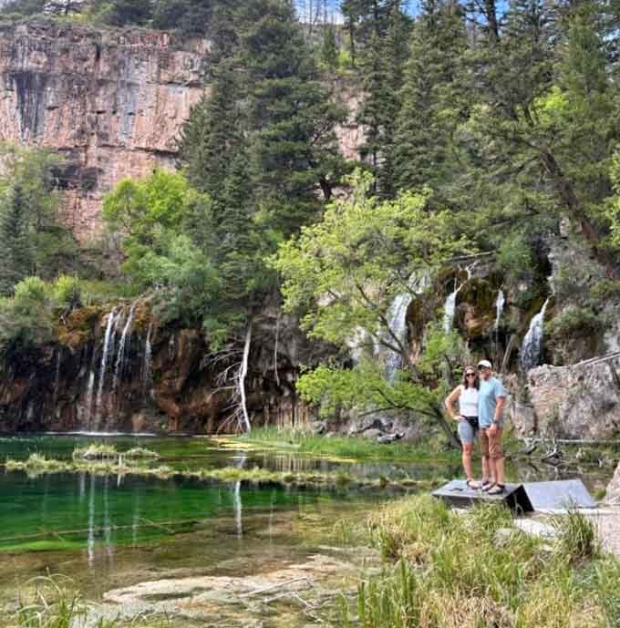 Visitors stand beside crystalline water, their smiles reflecting the achievement of conquering 1,000 feet of elevation gain.