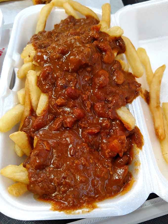 Rich, hearty chili smothering a basket of fries like a warm blanket on a cold Chicago evening, comfort food at its finest.