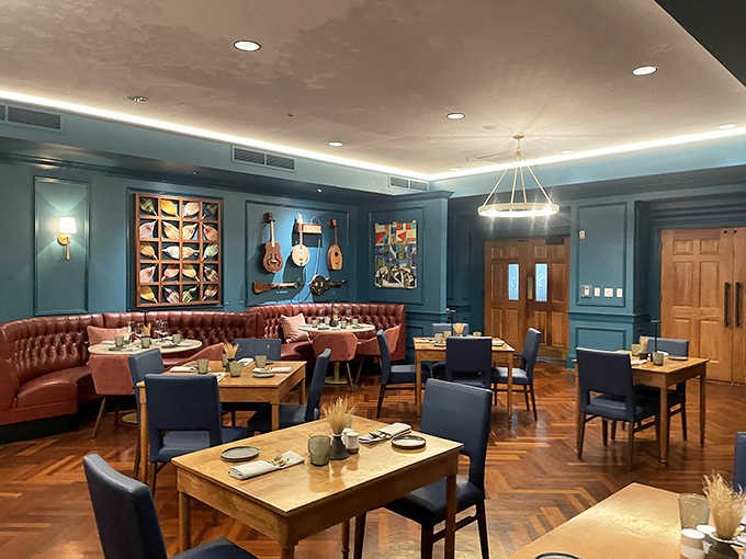 Deep teal walls, tufted leather booths, and folk art on display, a dining room with genuine personality and soul.