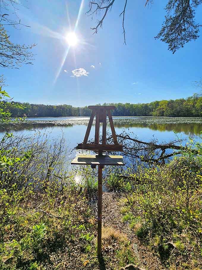 An artist's easel stands lakeside under a blazing sun. Someone had the right idea, and honestly, you should copy them.