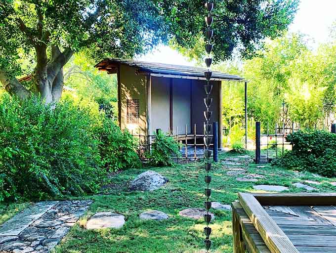 Tucked behind lush greenery, this quiet garden structure with its elegant rain chain feels like a secret the garden kept just for you.