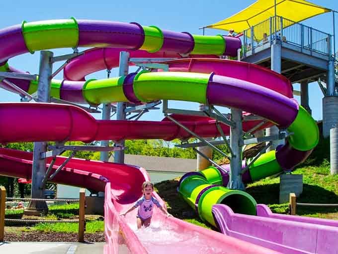 Twisting tubes of pink, purple, and green spiral down like a candy-colored fever dream, and kids absolutely love every second.