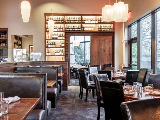 Leather booths, wine-lined shelves, and tall windows letting the outside world peek in. Every seat here feels like the best seat.