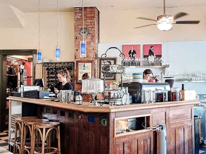 The bar area showcases exposed brick and vintage Parisian artwork, proving atmosphere matters as much as the food itself.