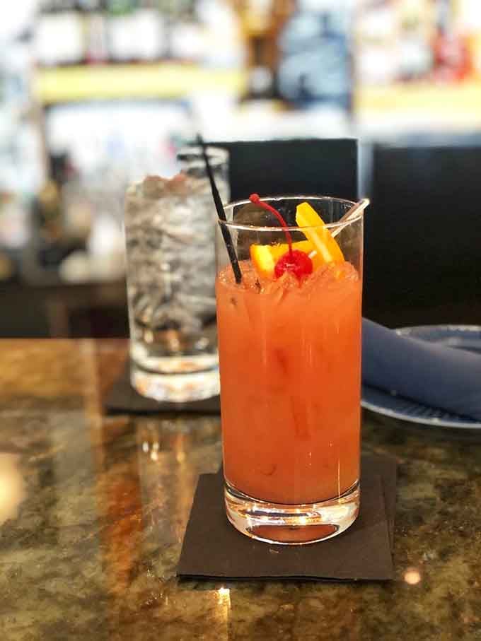 That coral-colored cocktail garnished with a cherry and orange peel is basically sunshine in a glass.