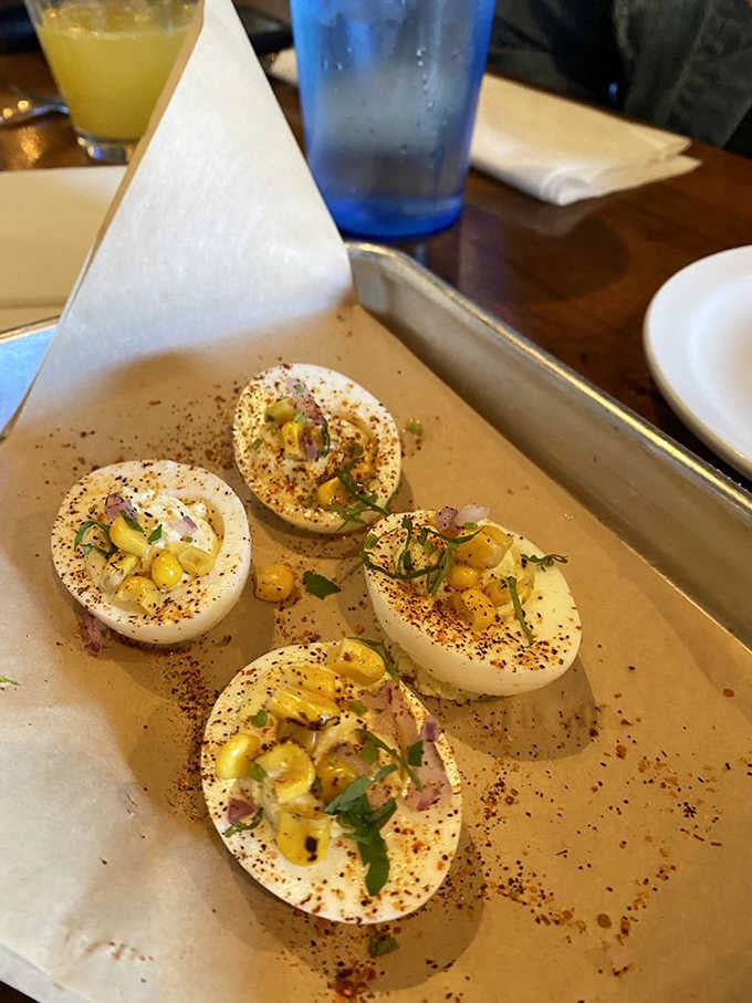 Deviled eggs with a Cajun twist, served on a baking sheet like a delicious secret someone almost kept to themselves.