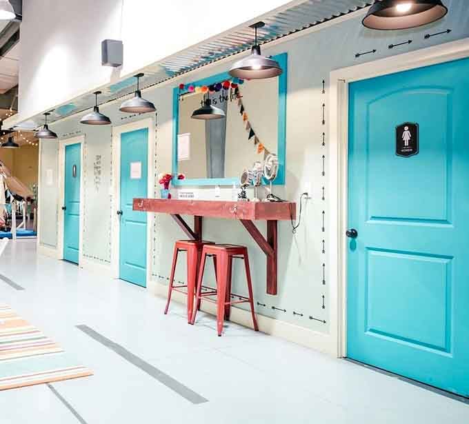 Even the restroom hallway here is decorated. Bright turquoise doors make a routine trip feel surprisingly delightful.