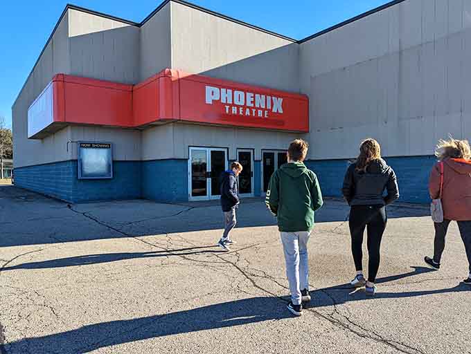 A small crowd gathers outside the Phoenix Theatre, because some things, like the shared excitement of movie night, never go out of style.