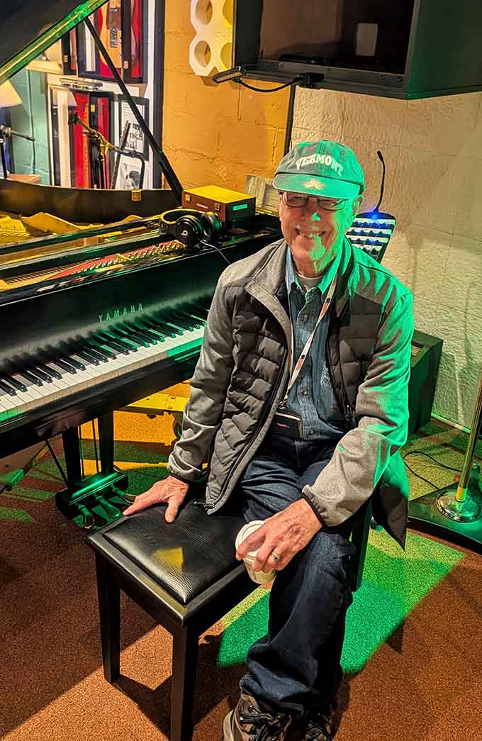 Sitting at the Yamaha piano bench with a smile that says everything. Some rooms just make people genuinely happy to be there.