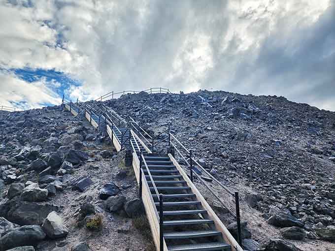 Metal stairs climbing straight up through the obsidian flow, because sometimes the best views require a little effort.
