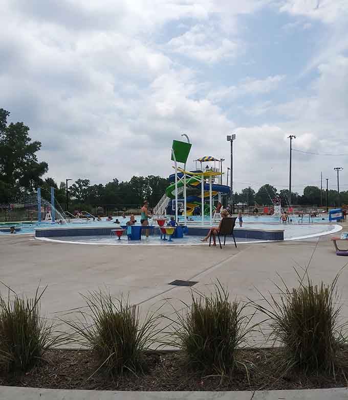 Colorful water play features, splashing kids, and a tipping bucket overhead. This little corner of the park runs entirely on pure childhood energy.