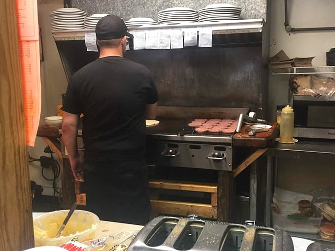 Burgers on the flat top, orders on the rail. This kitchen has been feeding people the right way.