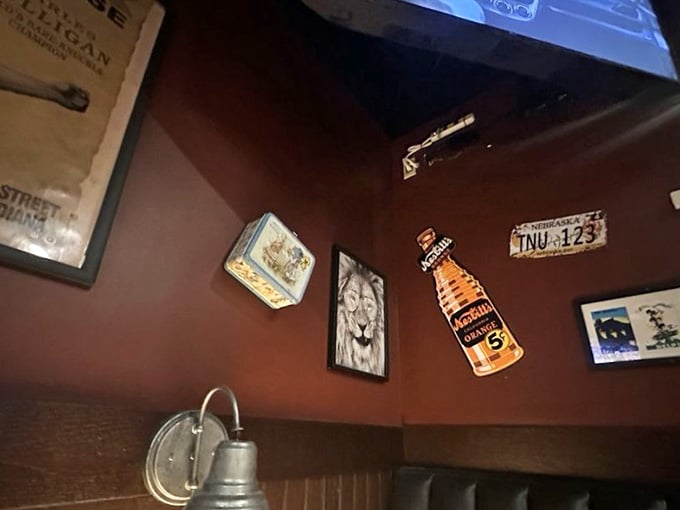 Old license plates, vintage soda signs, and framed artwork covering deep red walls. Every inch has something worth noticing.
