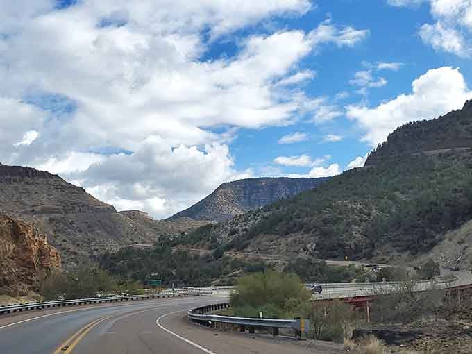 Gentle curves lead toward blue-tinged mountains, the kind of drive that makes you forget your destination entirely.
