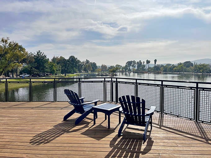 Two Adirondack chairs facing the tranquil water are basically whispering "sit down, relax, you've earned this" in unison.