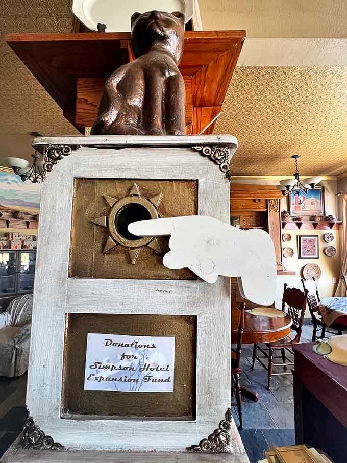 Even the donation box has personality here. A carved bear, a pointing hand, and a sun medallion walk into a lobby.