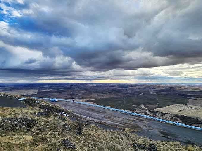 The access road winds upward like a ribbon, reminding you that good things require a little adventure.