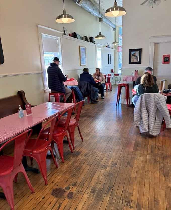 Diners settling in at red tables, living their best pie life in this charming riverside village cafe.