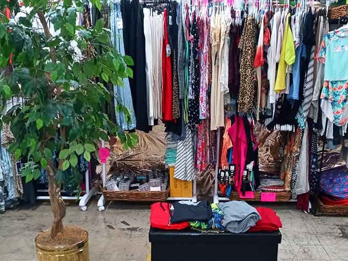Packed racks of colorful clothing stretch wall to wall, with a cheerful little tree standing guard over the whole scene.