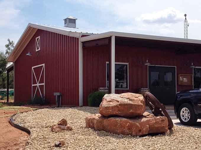 A red barn-style building offers weary travelers a place to rest surrounded by authentic West Texas landscape and charm.