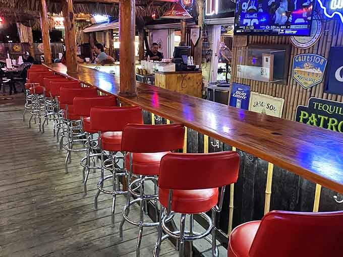 Red stools, a long wooden bar, and cold drinks waiting. This is exactly where you want to be after a long week.