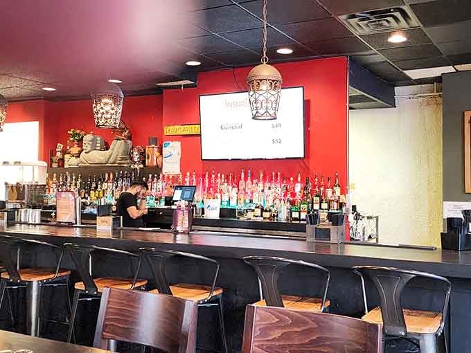 A fully stocked bar against a fire-engine red wall. Every great taco deserves an equally great drink beside it.