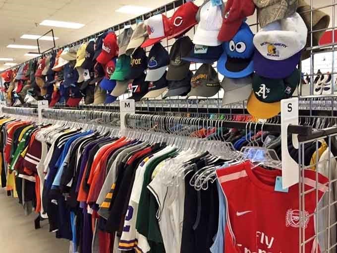 Sports jerseys, team caps, and athletic gear lined up like a thrift store hall of fame. Game on.