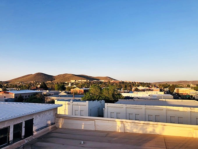 Alpine's rooftops bathed in golden evening light, with gentle hills rising in the distance. Pure, unhurried Texas magic.