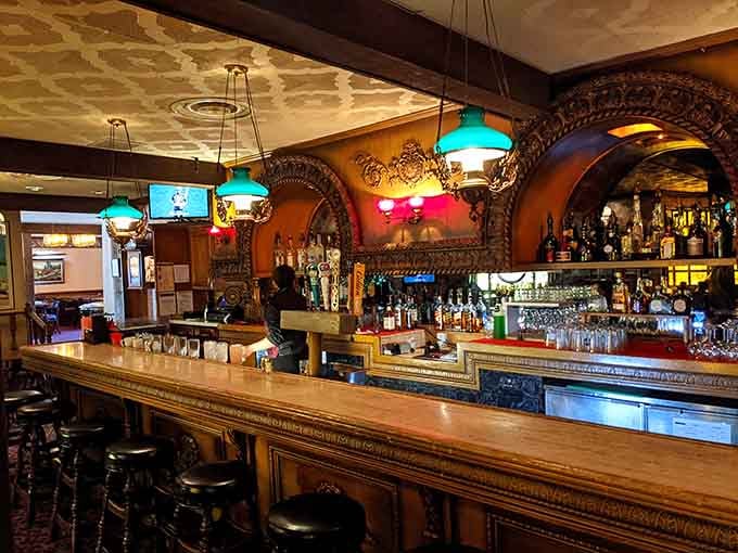 The bar gleams with polished wood and colorful bottles, ready to mix drinks that taste as good as the setting looks.
