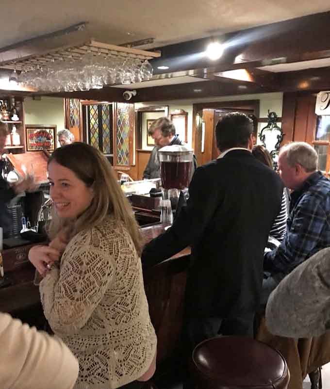 A cozy bar with stained glass accents and warm conversation flowing freely. History tastes better with a drink in hand.
