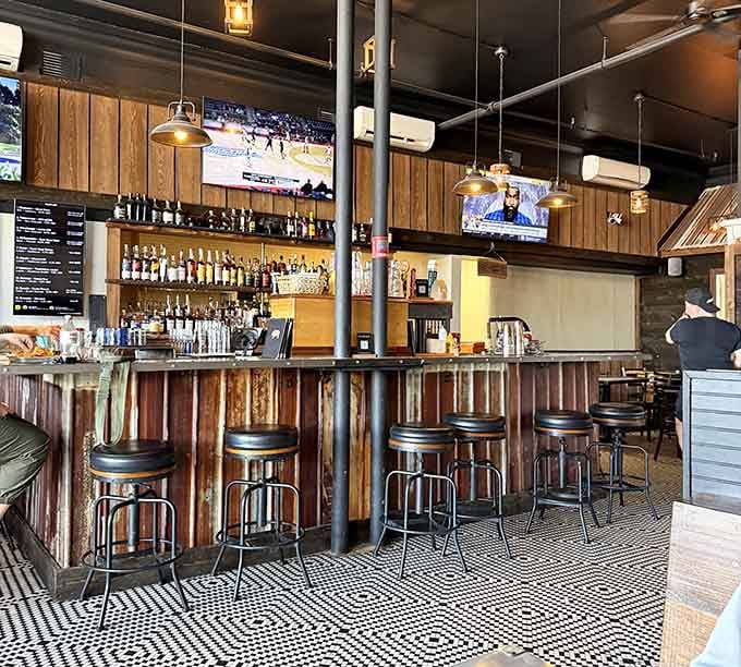 A well-stocked bar with TVs, good lighting, and bar stools that are clearly getting plenty of use.