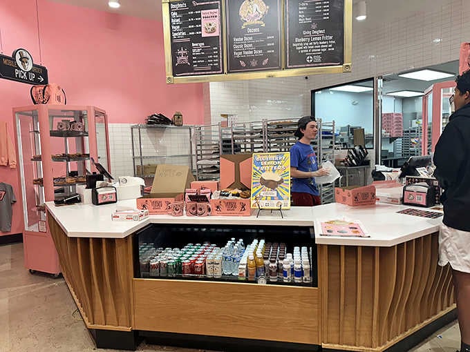 The counter displays pink boxes, bottled drinks, and enough temptation to ruin any diet instantly.
