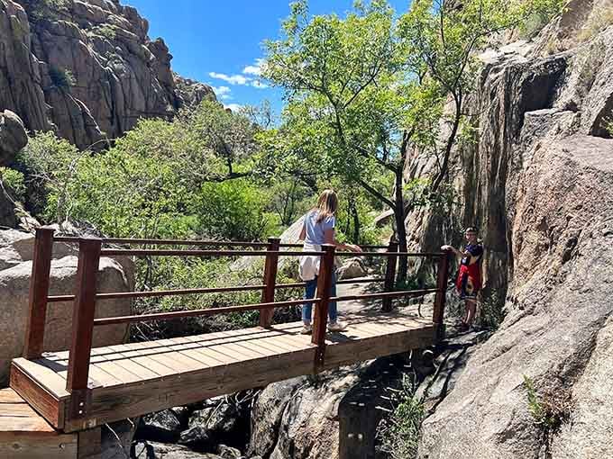 A wooden footbridge tucks neatly between granite walls, reminding you that the trail has a few surprises left.