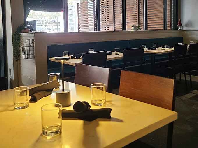 Warm yellow tabletops and dark banquette seating give this dining room a cozy, unhurried Saturday morning feeling.