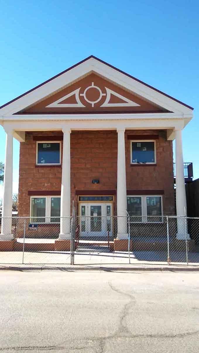 Solid brick, tall columns, and serious character. This building has been standing its ground longer than most of us have been alive.