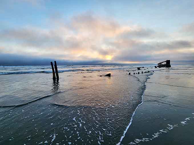Sunset wraps the wreck in amber and shadow, making the Pacific look like it swallowed something magnificent.