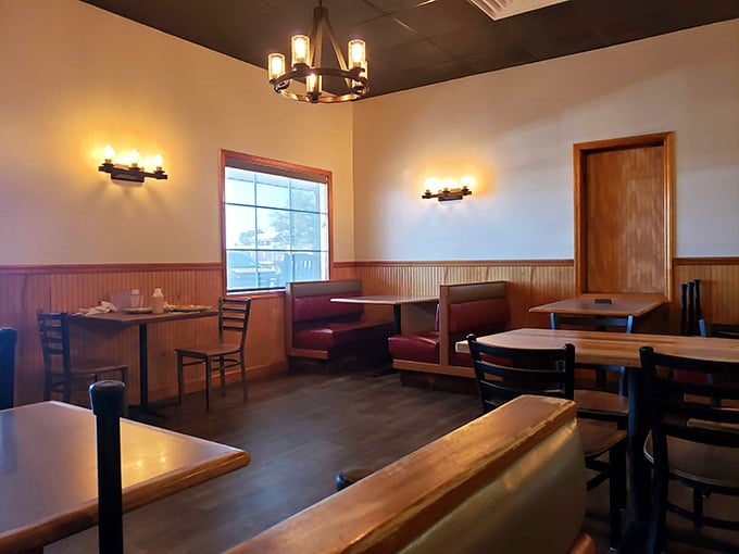 Rustic wood paneling, warm sconce lighting, and red booth seats, a dining room that says slow down and stay a while.