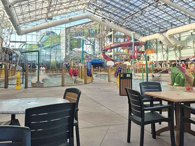 Tables and chairs scattered across the open floor, slides looping overhead, and a frog sculpture nearby, this is a very good afternoon.