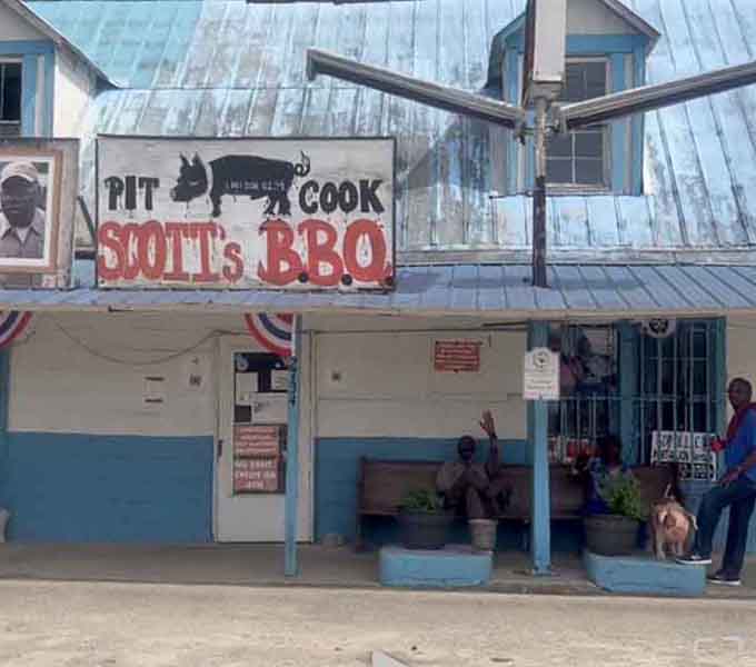 That iconic pit cook sign with its bold red lettering tells you everything you need to know before you even smell the smoke.