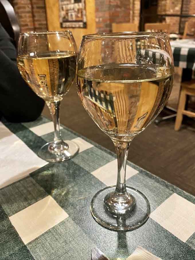 Two glasses of white wine on a checkered tablecloth. Some evenings are simply meant to be savored slowly.