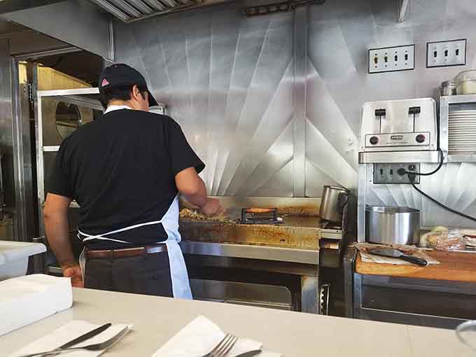 Behind that counter, the flat top griddle is the real star of the show, and the cook knows it well.