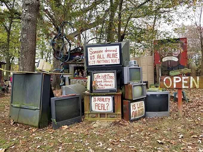 Stacked televisions asking "Is Reality Real?" in a Kentucky yard, which is either profound philosophy or the best yard art ever made.