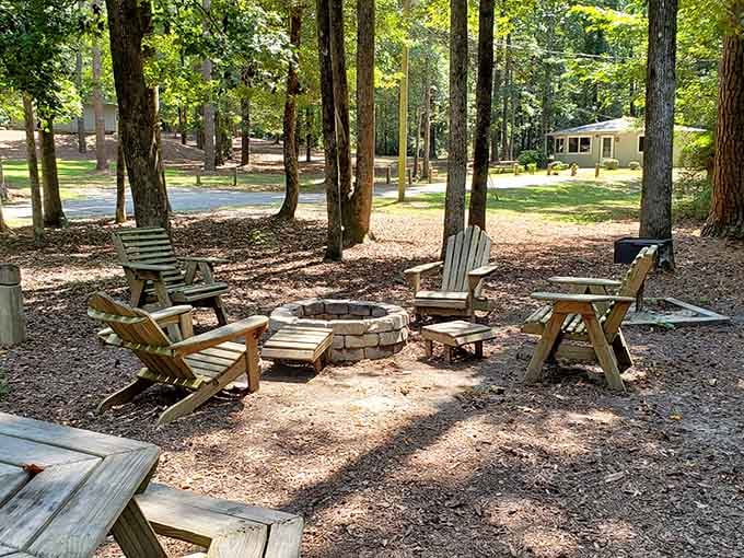 Six Adirondack chairs circling a stone fire pit, dappled in afternoon sunlight. This is the meeting room everyone actually wants to attend.