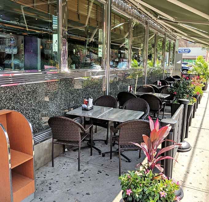 Outdoor seating with fresh flowers and wicker chairs, because sometimes Astoria deserves to be enjoyed al fresco.