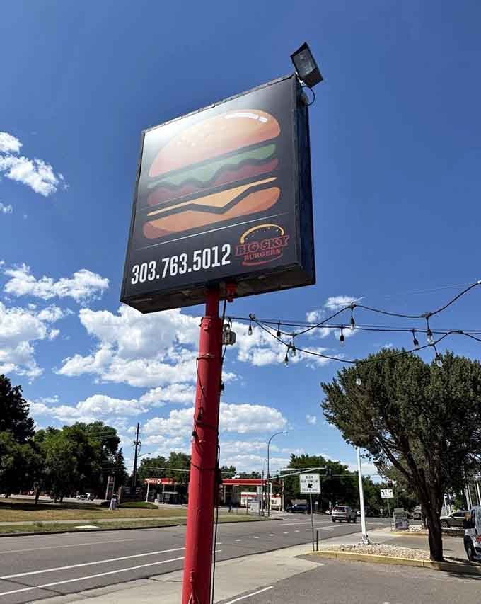 A bold roadside sign against a Colorado blue sky. This is the kind of landmark that makes you hit the brakes and turn around.