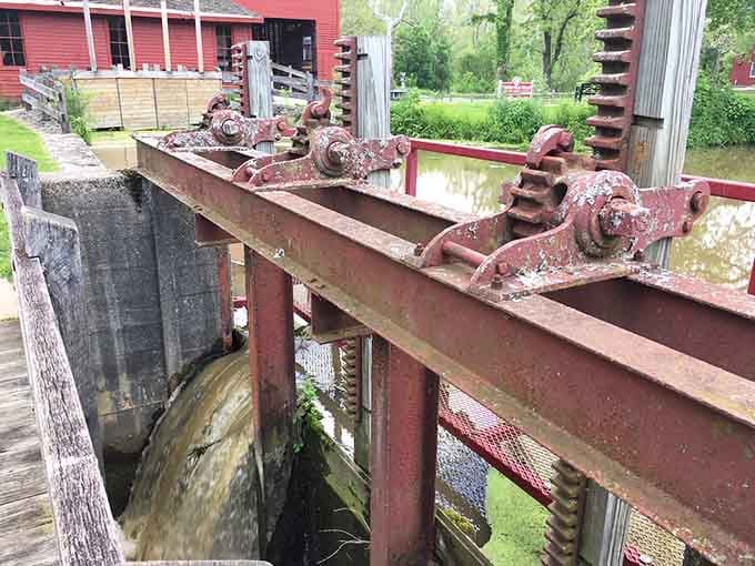 Rusted iron gears controlling the flow of water that powers a mill. Old-school engineering that still gets the job done.