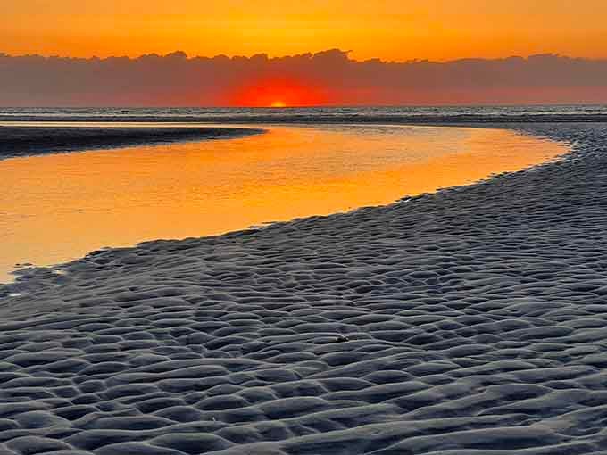 A winding tidal stream catches the fiery sunset sky, turning the Brewster Tidal Flats into something almost unreal.