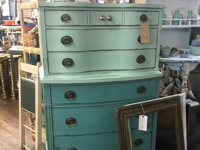 That teal painted dresser is the most confident piece of furniture in the room, and honestly, it has every right to be.