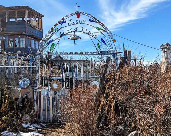 Colored glass bottles, hubcaps, and a cross on top. The most welcoming entrance you never expected to find.